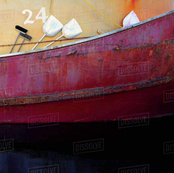 Lifeboat floating by ship in harbor - Stock Photo - Dissolve
