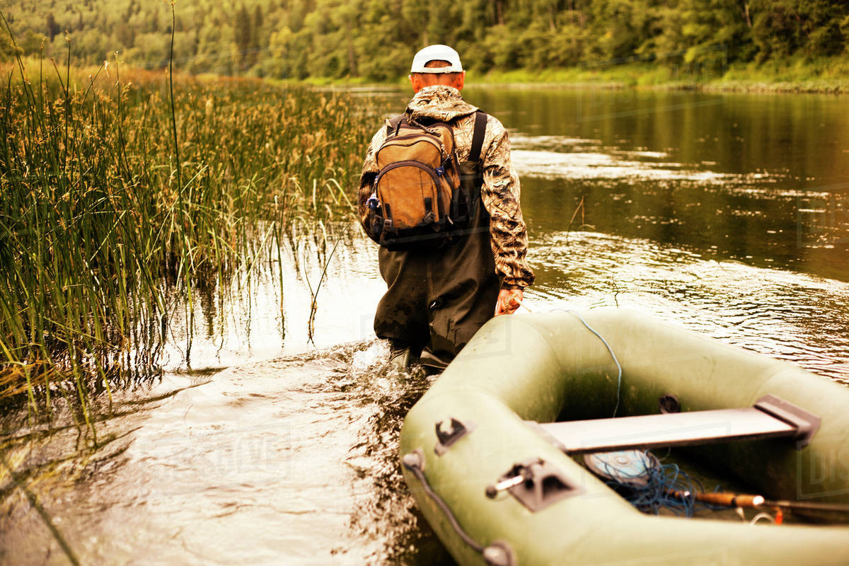 Mari fisherman pulling boat through lake - Stock Photo - Dissolve