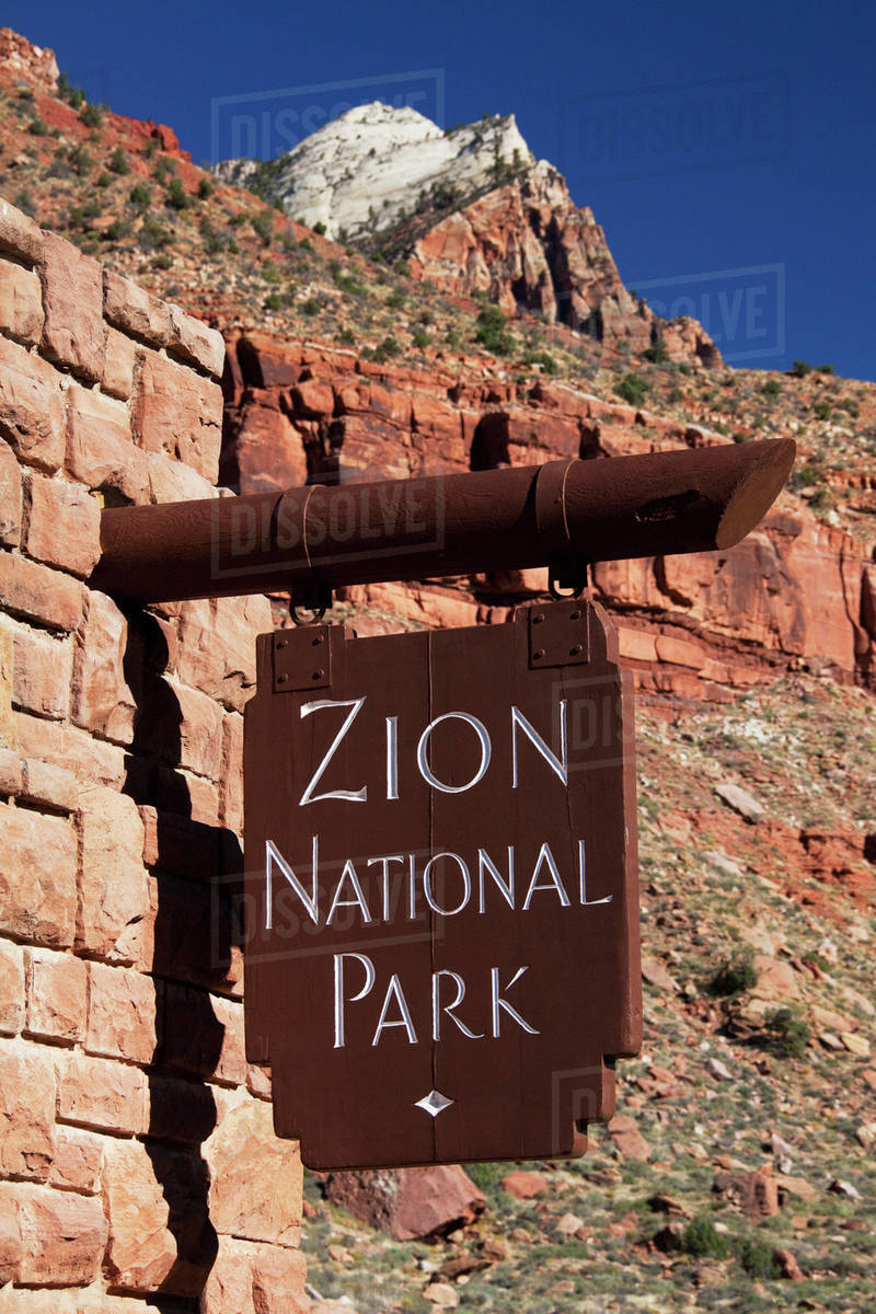 Close up of Zion National Park sign on stone wall, Utah, United States ...