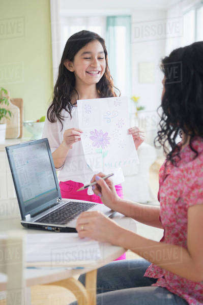 Hispanic girl proudly showing drawing to mother - Royalty-free Stock ...