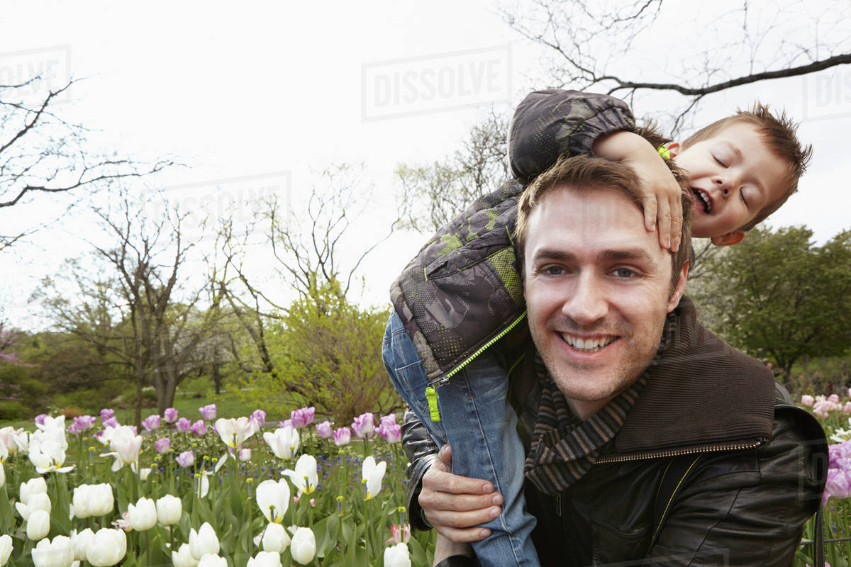 Father carrying son in park - Royalty-free Stock Photo | Dissolve