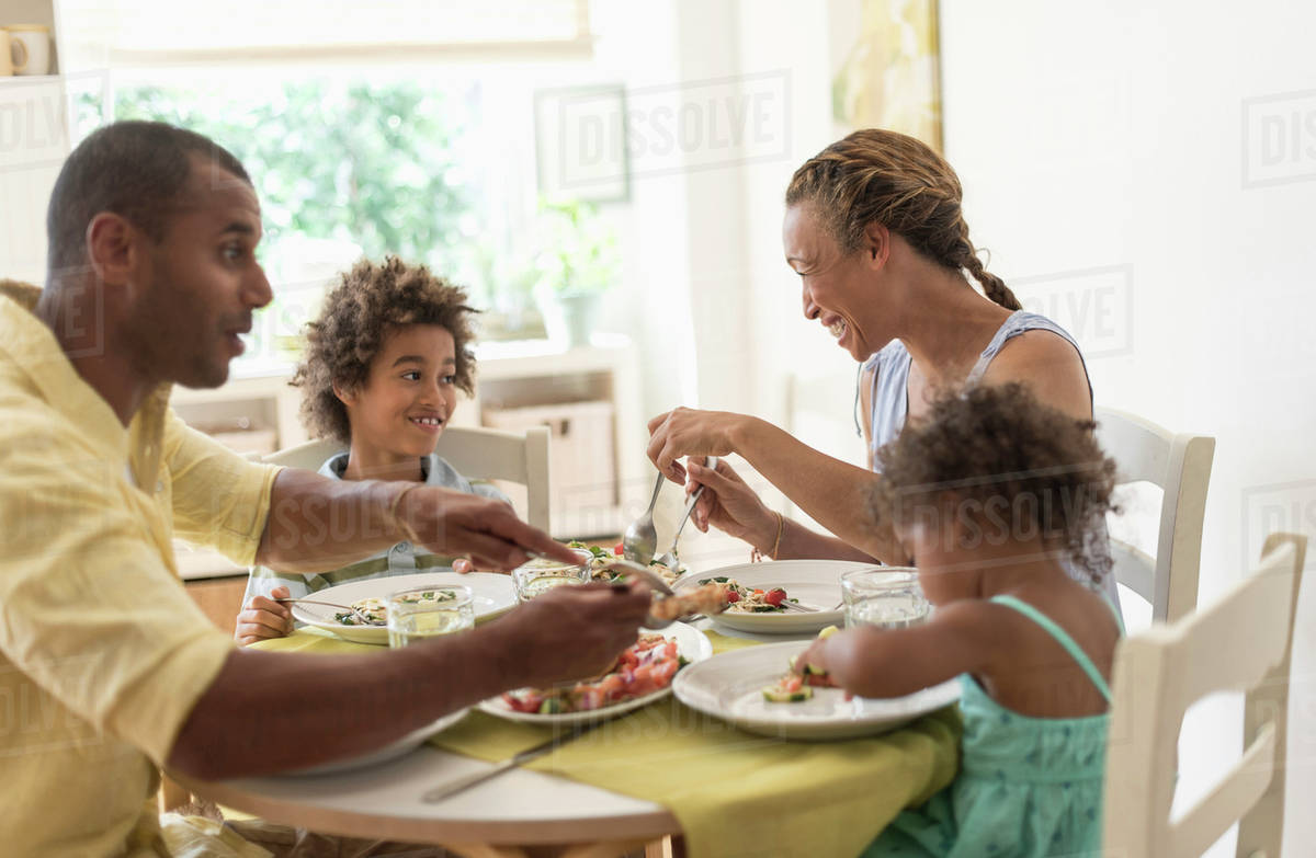 Family eating together at dining room table - Stock Photo - Dissolve