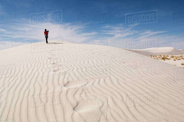 Man climbing sand dune in desert - Royalty-free Stock Photo | Dissolve
