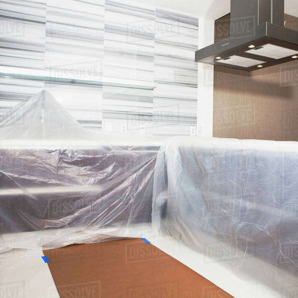 Tarps covering surfaces in modern kitchen under renovation - Stock ...