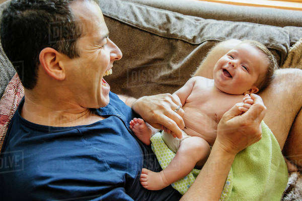 Caucasian father laughing with baby boy on sofa - Royalty-free Stock ...