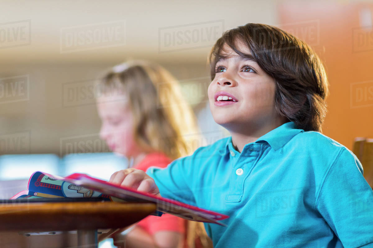 Student reading book at desk - Royalty-free Stock Photo | Dissolve
