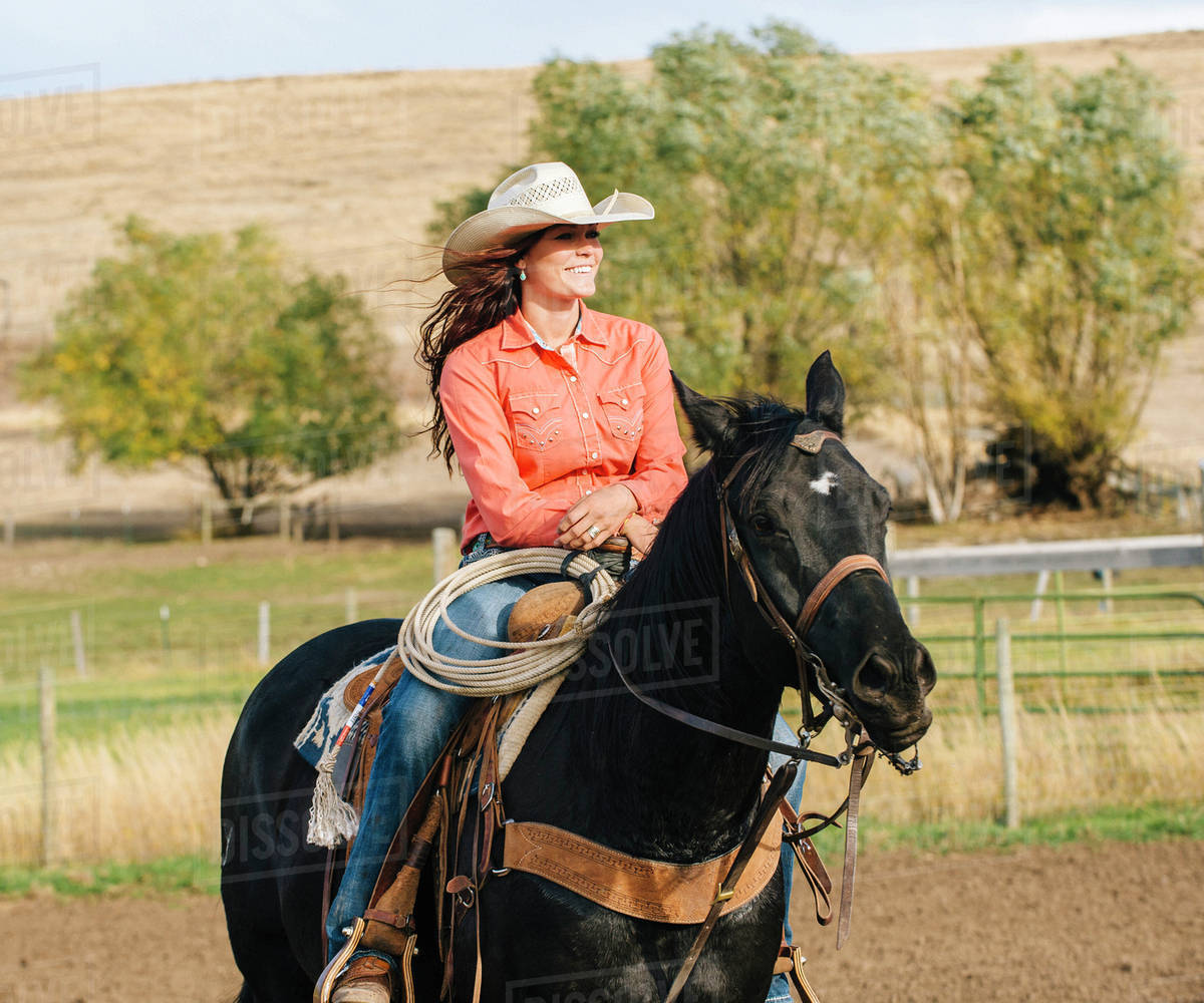 Caucasian woman riding horse on ranch - Royalty-free Stock Photo | Dissolve