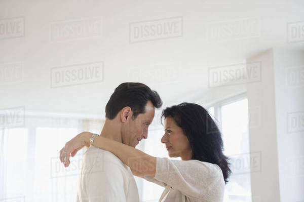 Couple hugging indoors - Royalty-free Stock Photo | Dissolve