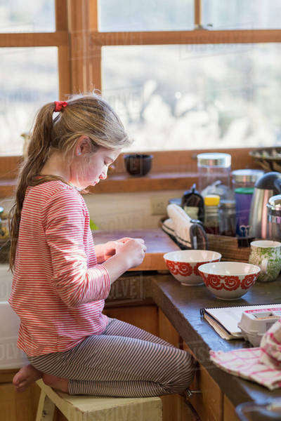 Caucasian girl cooking in kitchen - Royalty-free Stock Photo | Dissolve
