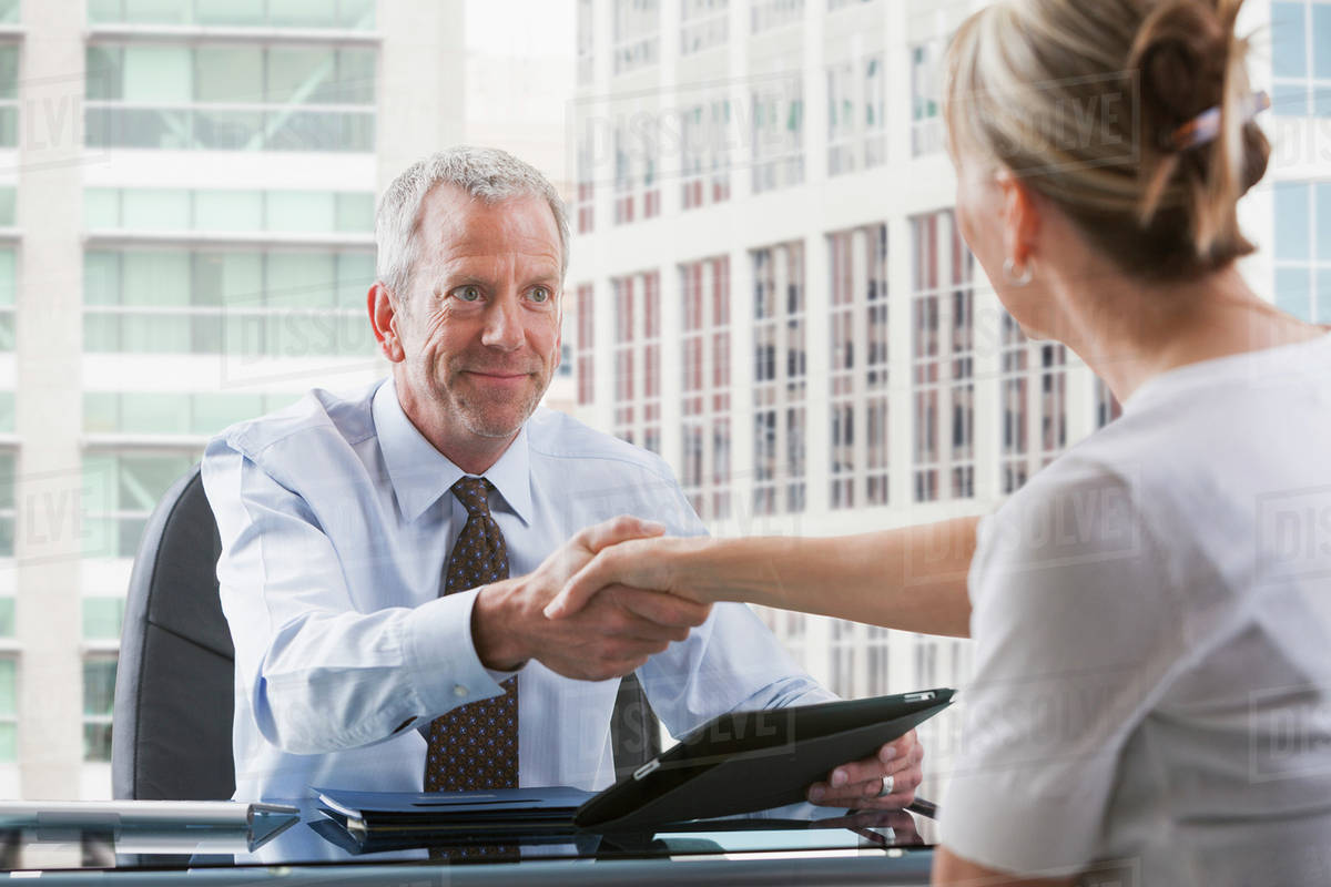 Caucasian businessman shaking hands with client - Stock Photo - Dissolve