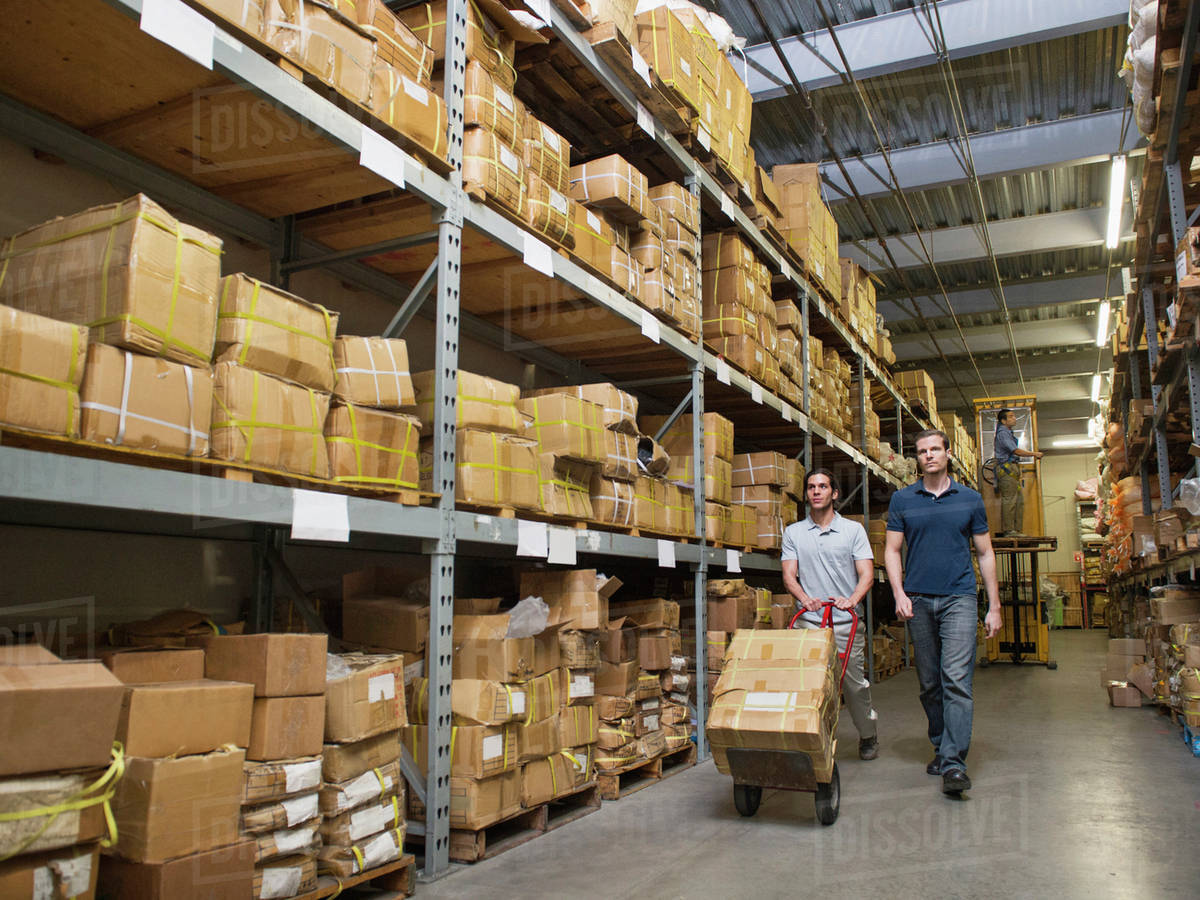 Workers carting boxes in textile factory - Stock Photo - Dissolve