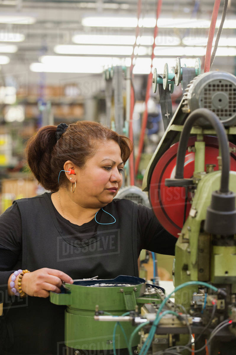 Hispanic worker operating machinery in textile factory - Royalty-free ...