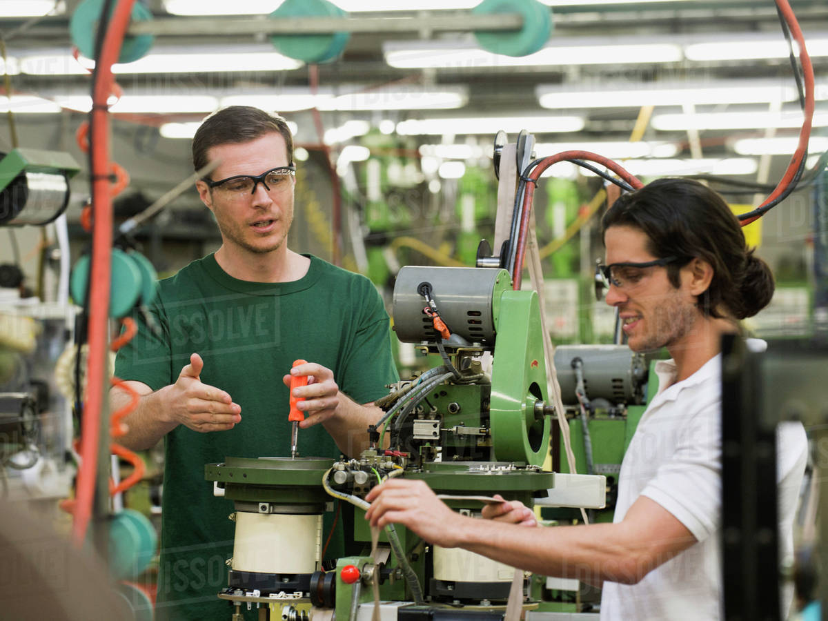 Workers operating machinery in textile factory - Stock Photo - Dissolve