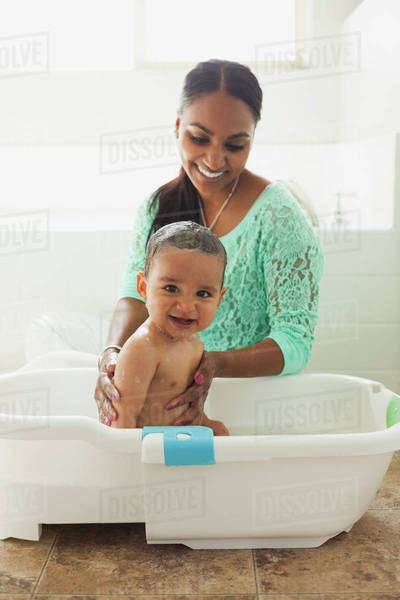 Mother bathing baby son in tub - Stock Photo - Dissolve