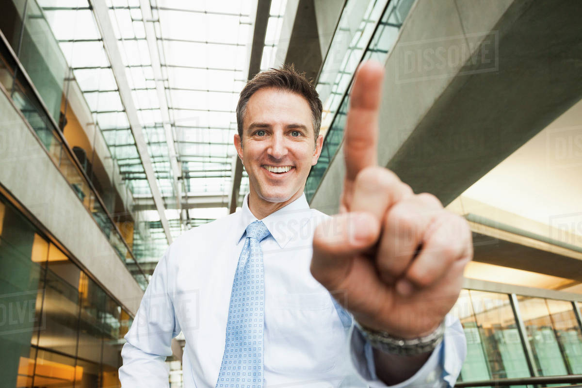 Caucasian businessman holding up finger - Stock Photo - Dissolve