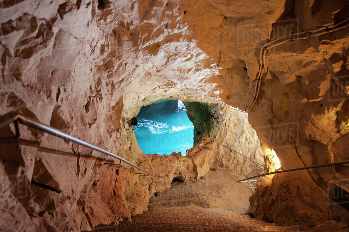 Railing inside illuminated cave, Israel, - Stock Photo - Dissolve