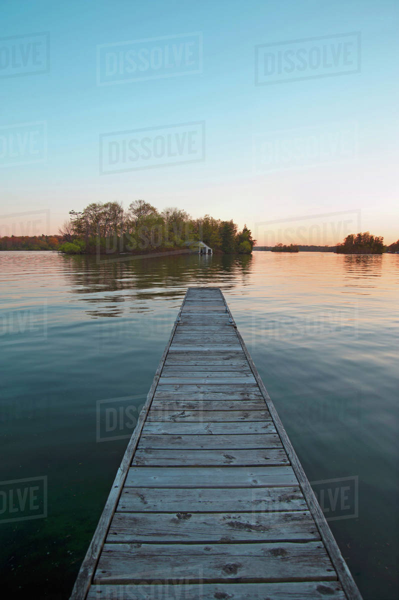 Wooden dock leading to lake - Royalty-free Stock Photo | Dissolve