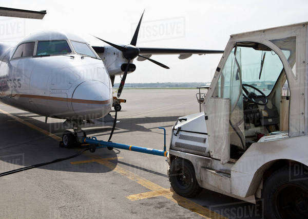 Airplane and cart parked on runway - Stock Photo - Dissolve