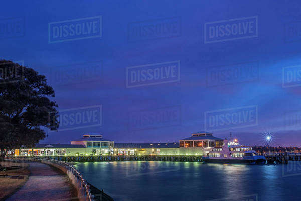 Harbor and boat lit up at dusk - Royalty-free Stock Photo | Dissolve