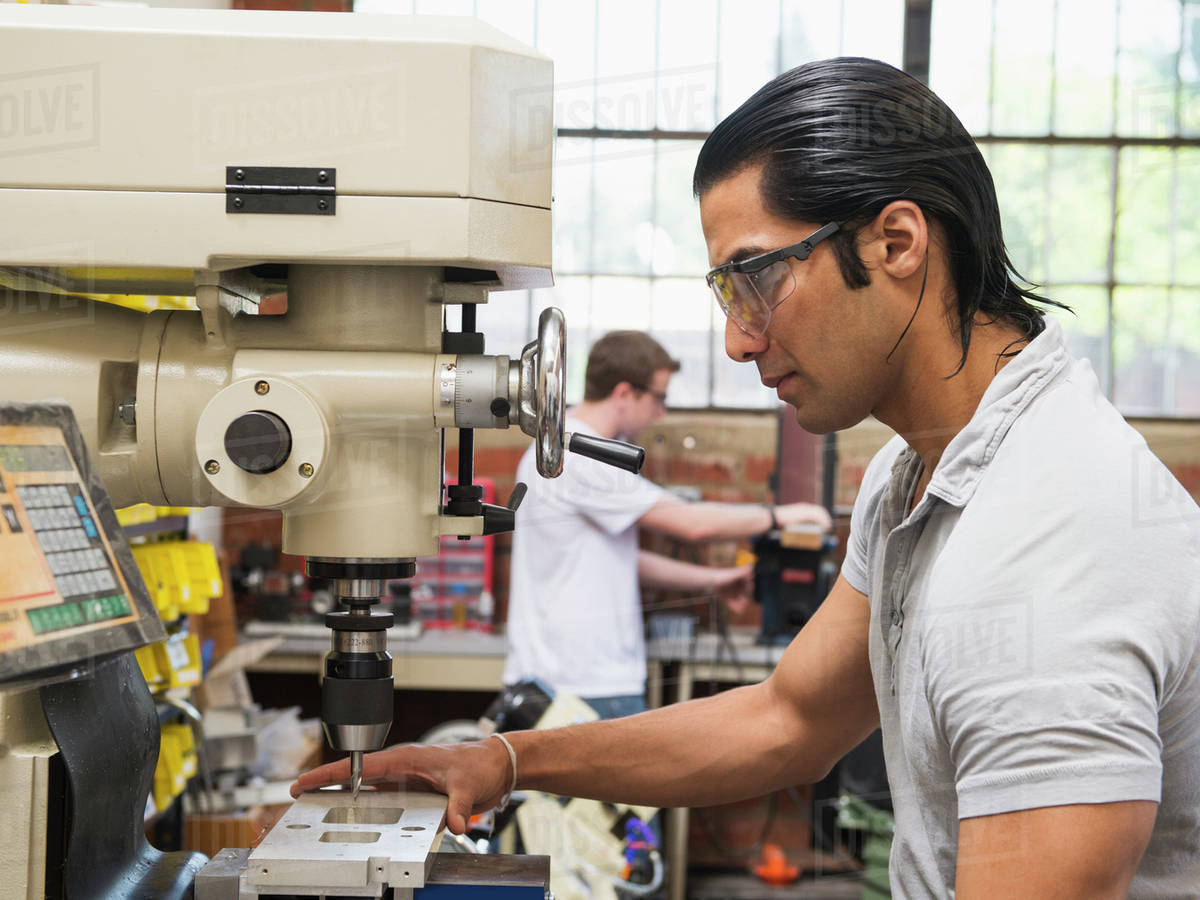 Workers using machinery in machine shop - Royalty-free Stock Photo ...