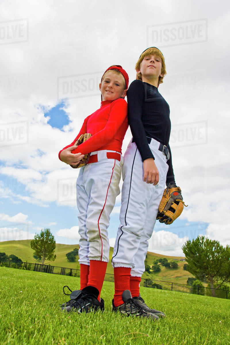 Baseball players standing back to back in field - Stock Photo - Dissolve