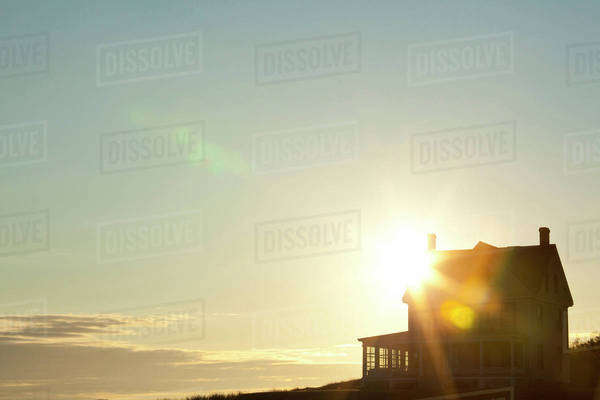 Sun shining behind rural house - Royalty-free Stock Photo | Dissolve
