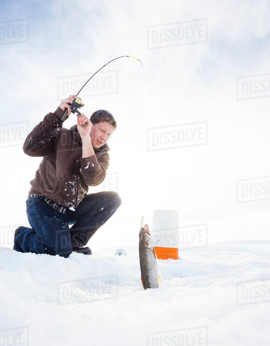 Caucasian man ice fishing - Royalty-free Stock Photo | Dissolve