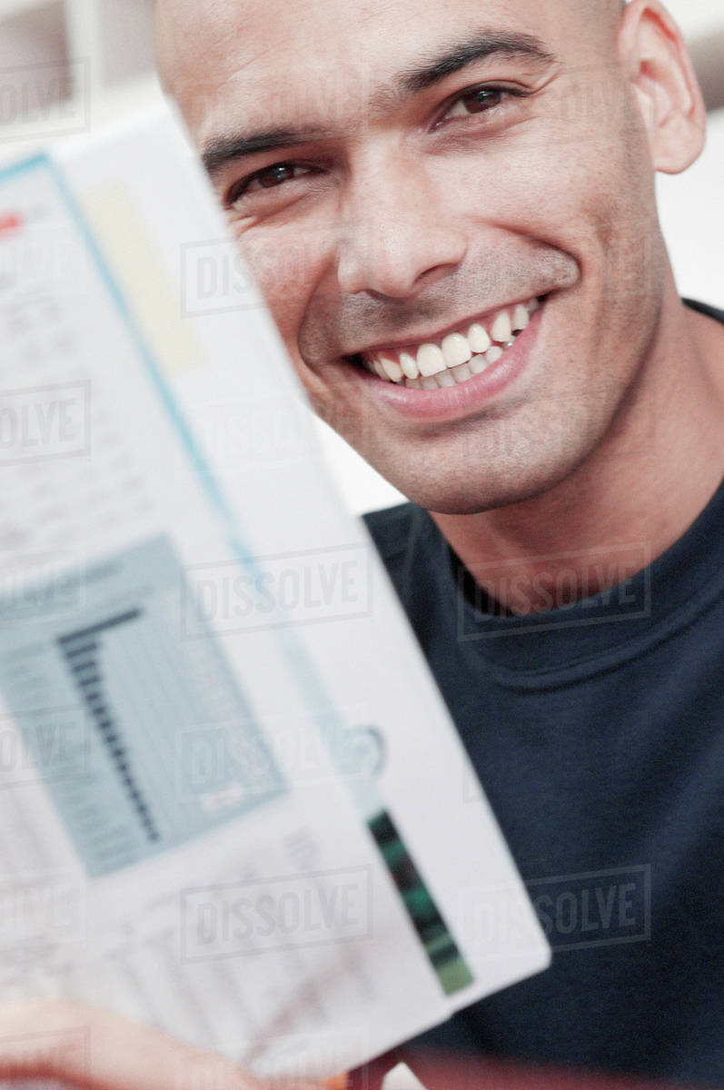 Smiling man reading magazine - Royalty-free Stock Photo | Dissolve