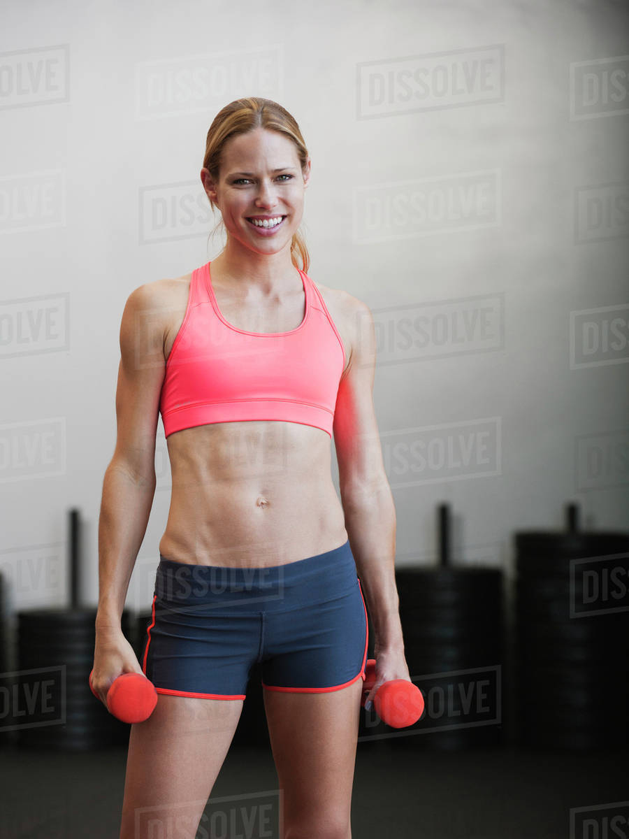 Caucasian woman using dumbbells - Royalty-free Stock Photo | Dissolve
