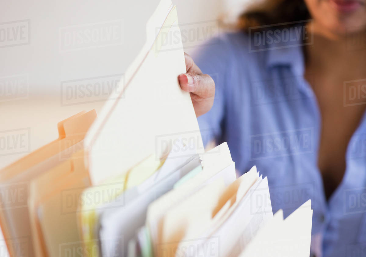 Cape Verdean woman picking up file folder - Royalty-free Stock Photo ...