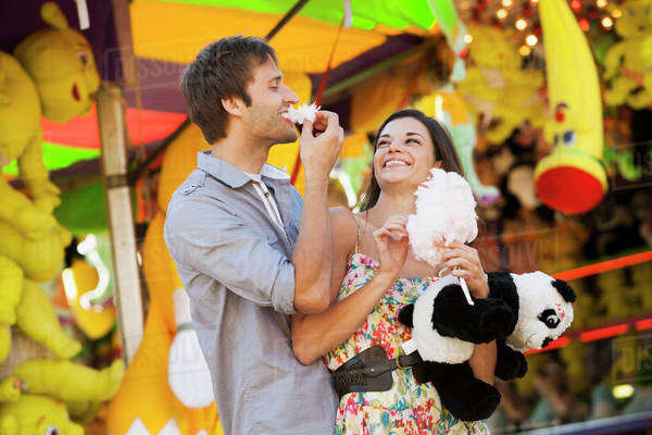 Caucasian couple sharing cotton candy at carnival - Royalty-free Stock ...