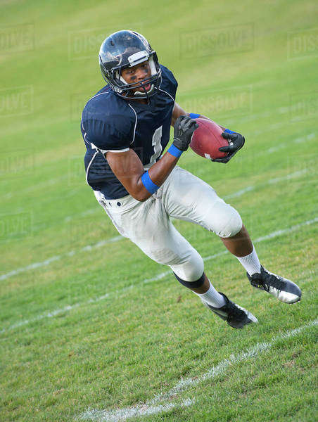 African American football player carrying ball - Royalty-free Stock ...