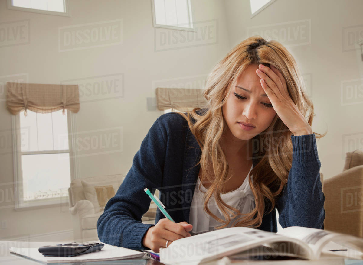 Anxious mixed race woman studying - Stock Photo - Dissolve