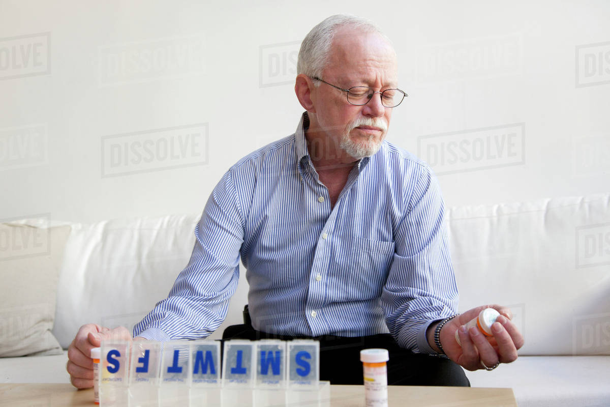Caucasian man taking pills - Royalty-free Stock Photo | Dissolve