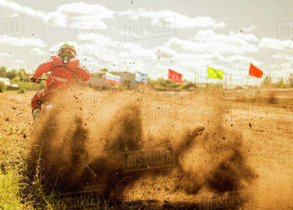 Caucasian motocross biker spraying dirt on race course - Royalty-free ...