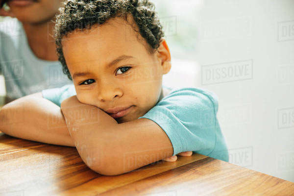 Close up of boy leaning on table - Royalty-free Stock Photo | Dissolve