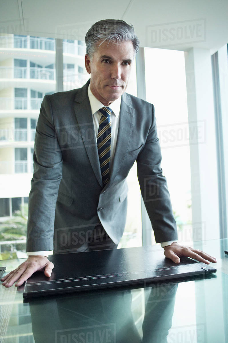 Caucasian businessman standing at desk in office - Royalty-free Stock ...