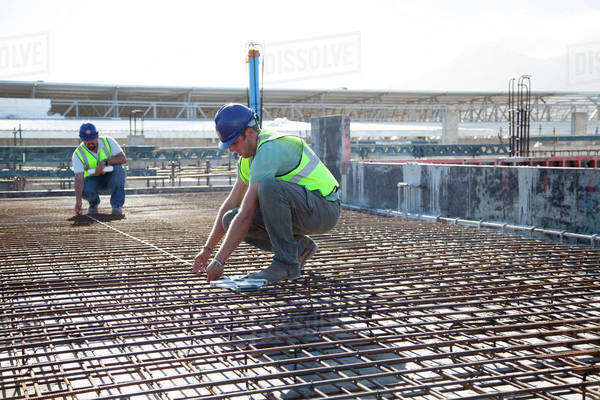Construction workers arranging rebar at construction site - Royalty ...