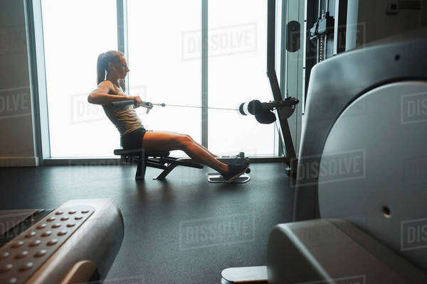 Woman using exercise machine in gym - Royalty-free Stock Photo | Dissolve