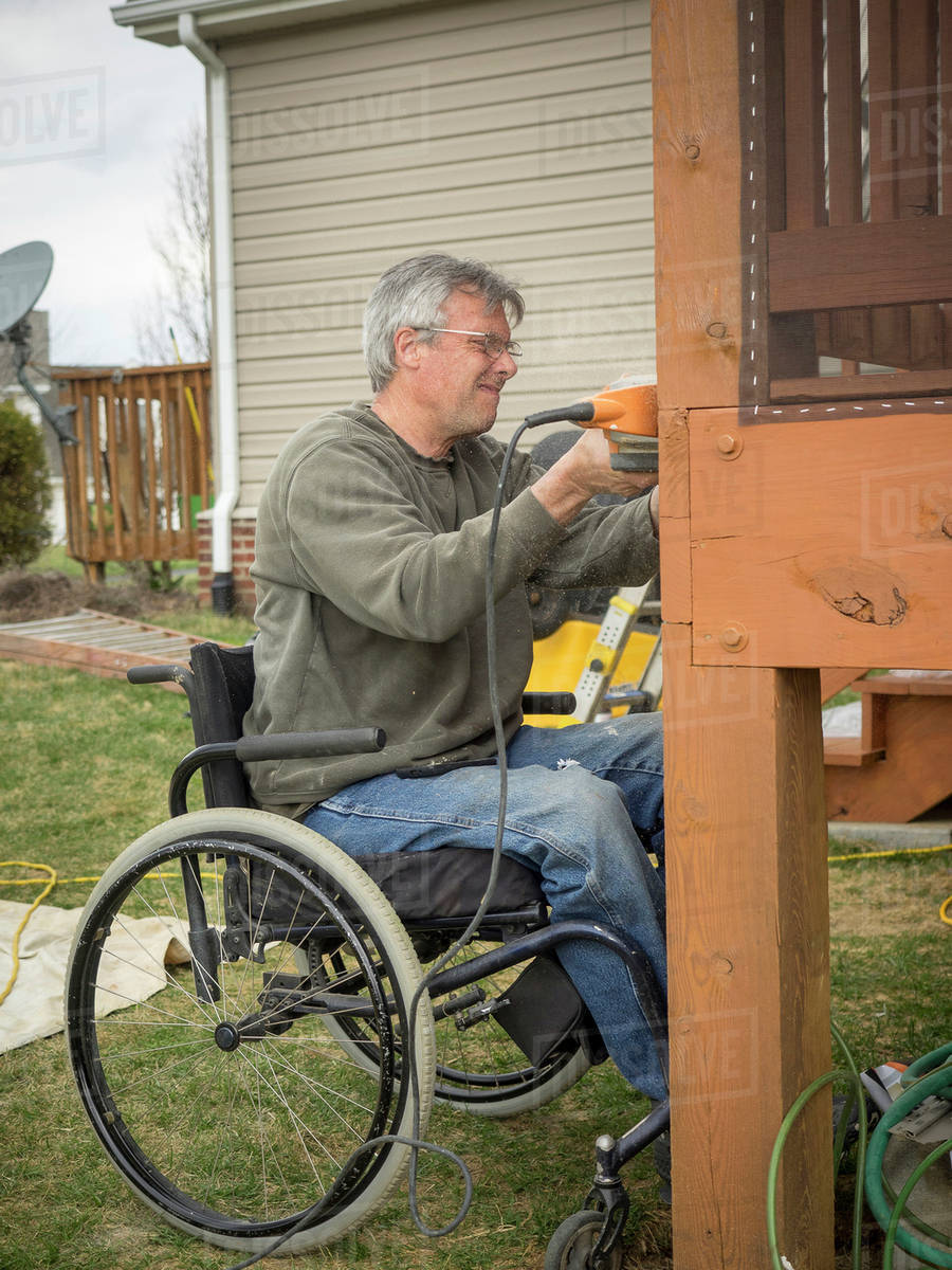 Caucasian paraplegic man wood working in backyard - Royalty-free Stock ...