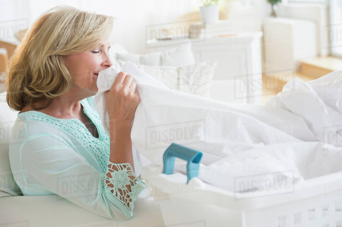Caucasian woman smelling clean laundry - Royalty-free Stock Photo ...