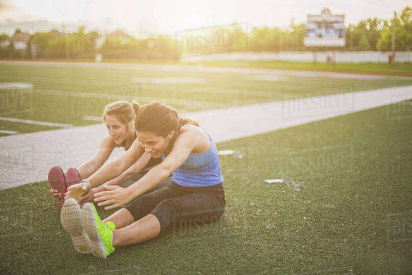 Athletes stretching on sports field - Royalty-free Stock Photo | Dissolve