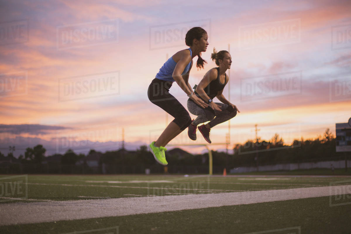 Athletes jumping on sports field - Royalty-free Stock Photo | Dissolve