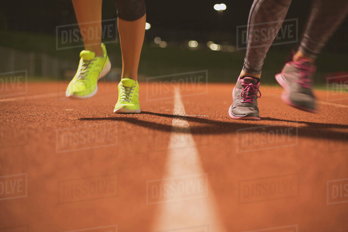 Athletes running on track on sports field - Stock Photo - Dissolve