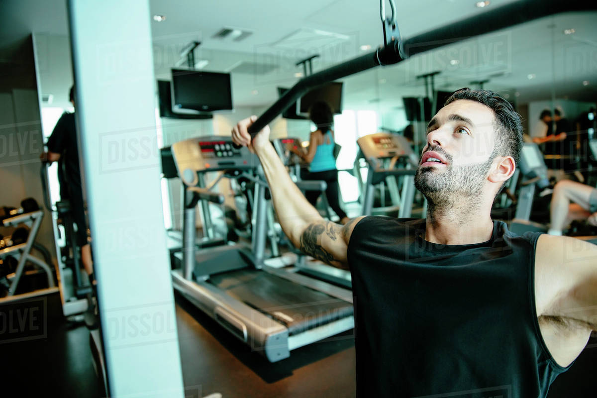 Man using exercise machine in gymnasium - Royalty-free Stock Photo ...