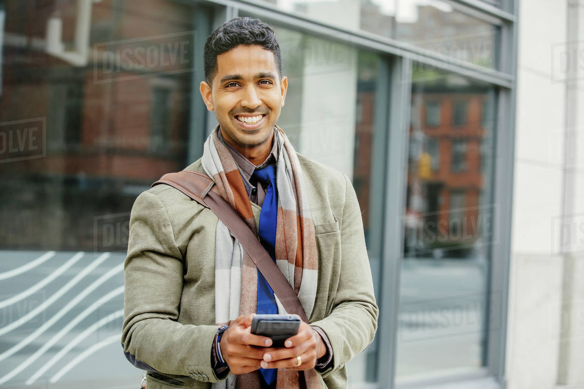 Indian man using cell phone in city - Royalty-free Stock Photo | Dissolve
