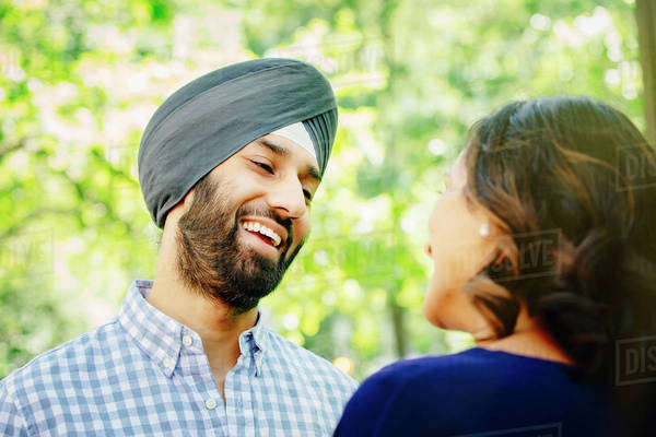 Indian couple talking in urban park - Stock Photo - Dissolve