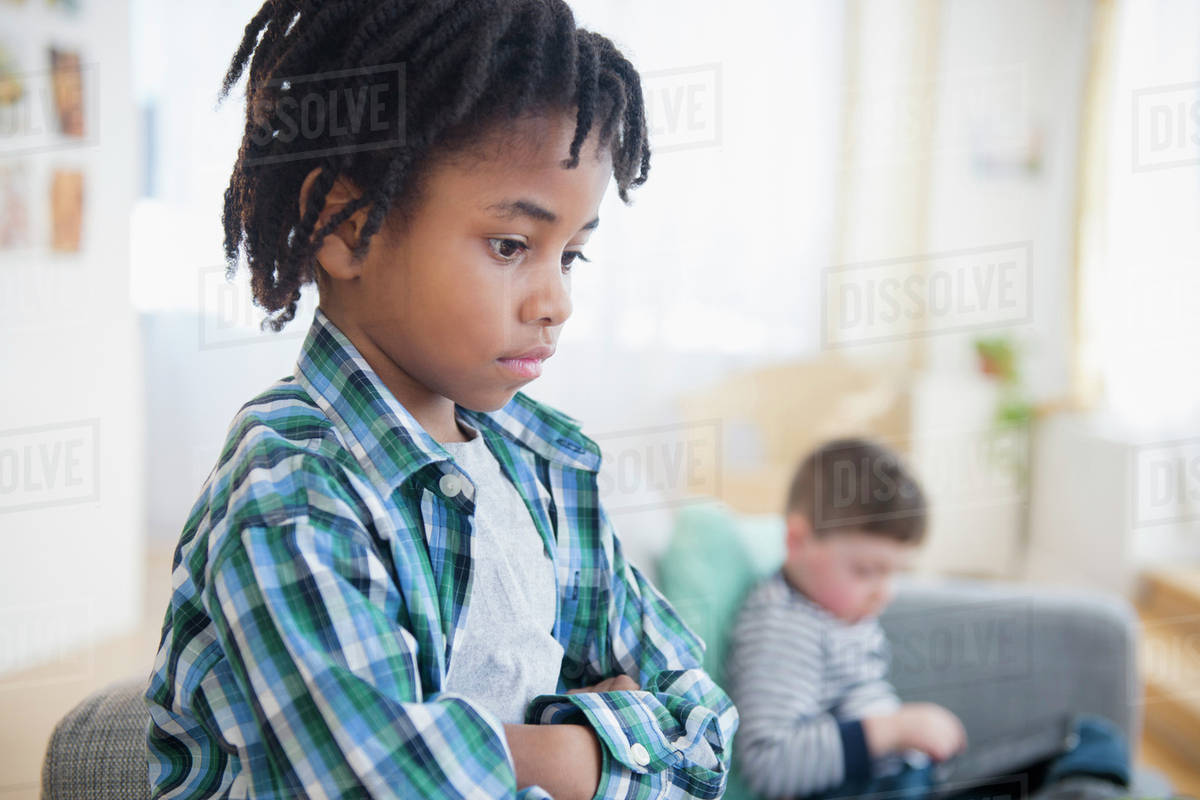 Boy ignoring friend in living room - Stock Photo - Dissolve