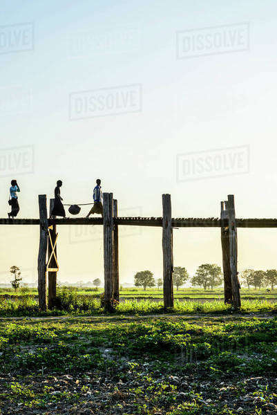 People walking on elevated wooden walkway in rural landscape - Royalty ...