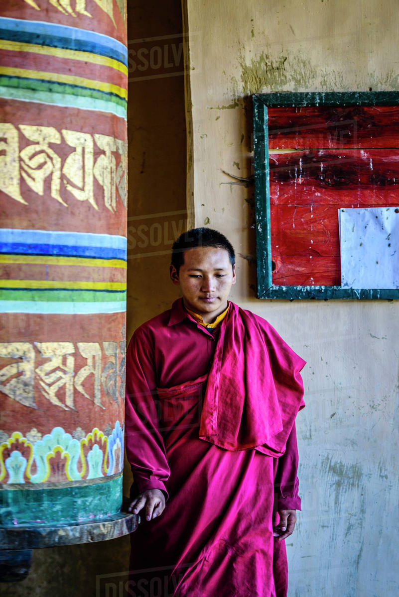 Asian monks standing by pillar in temple - Stock Photo - Dissolve